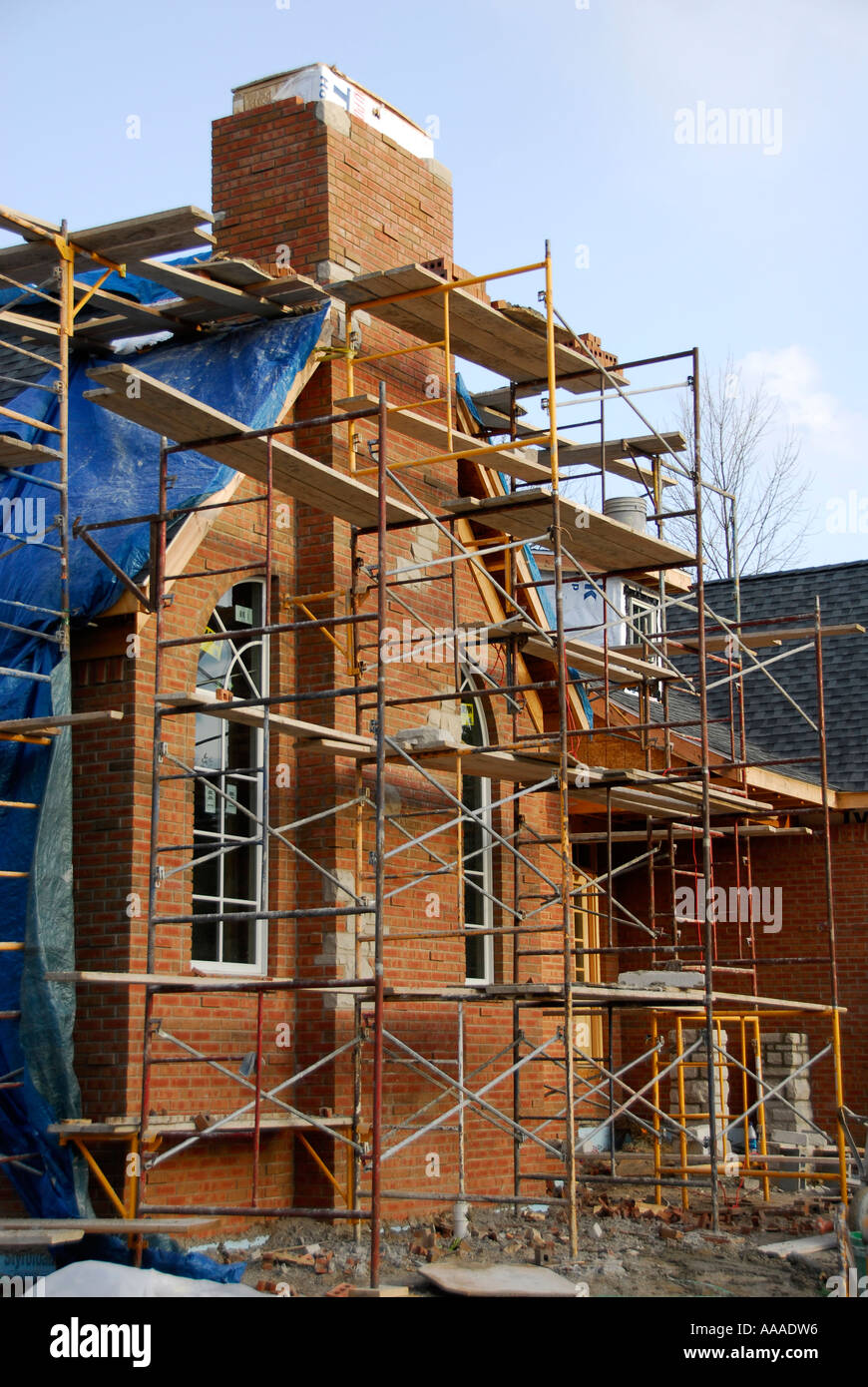 New home construction using scaffolding to complete exterior brick work ...