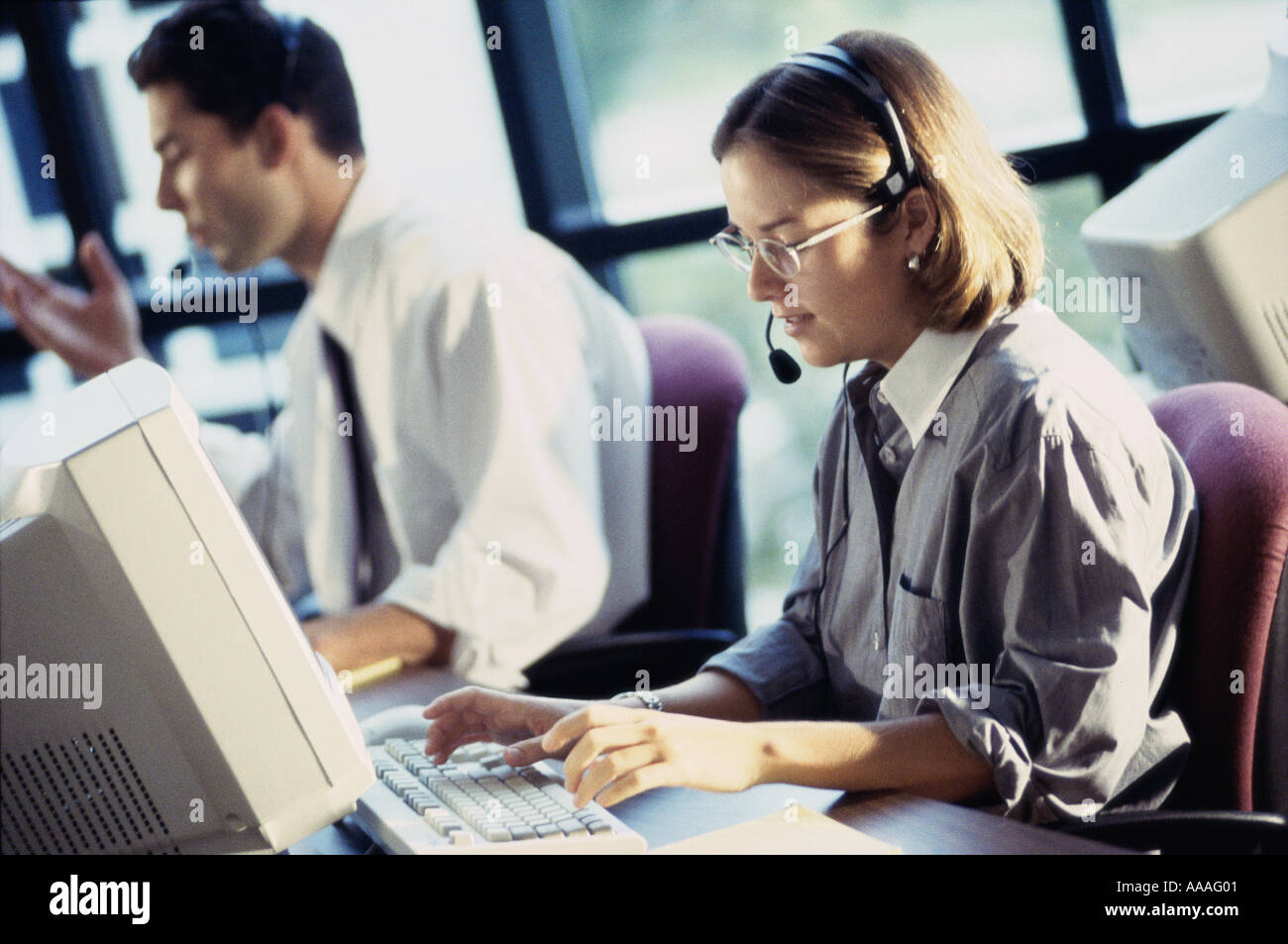 Customer service representatives sitting in front of computer monitors ...