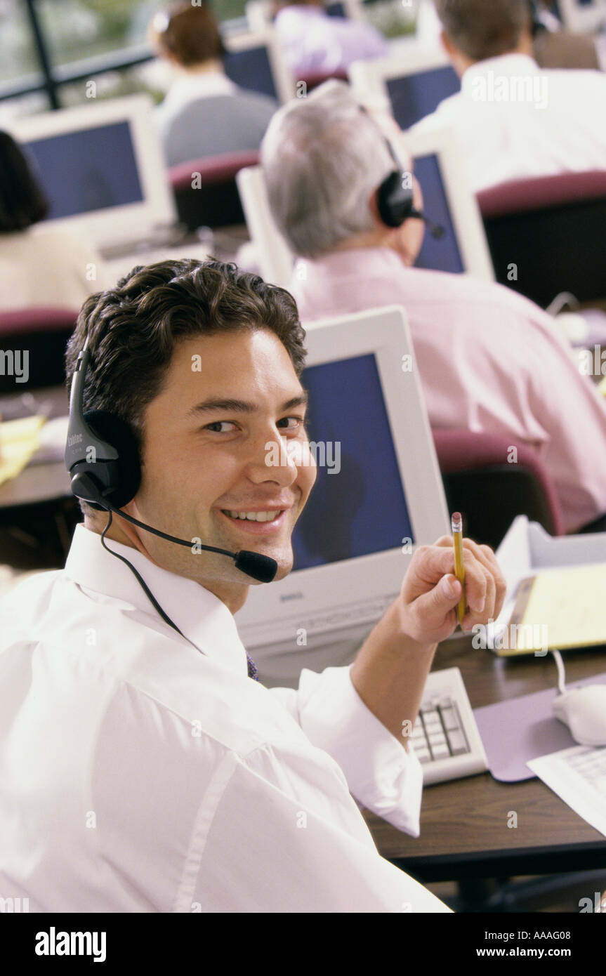 Portrait of a male customer service representative sitting in front of ...