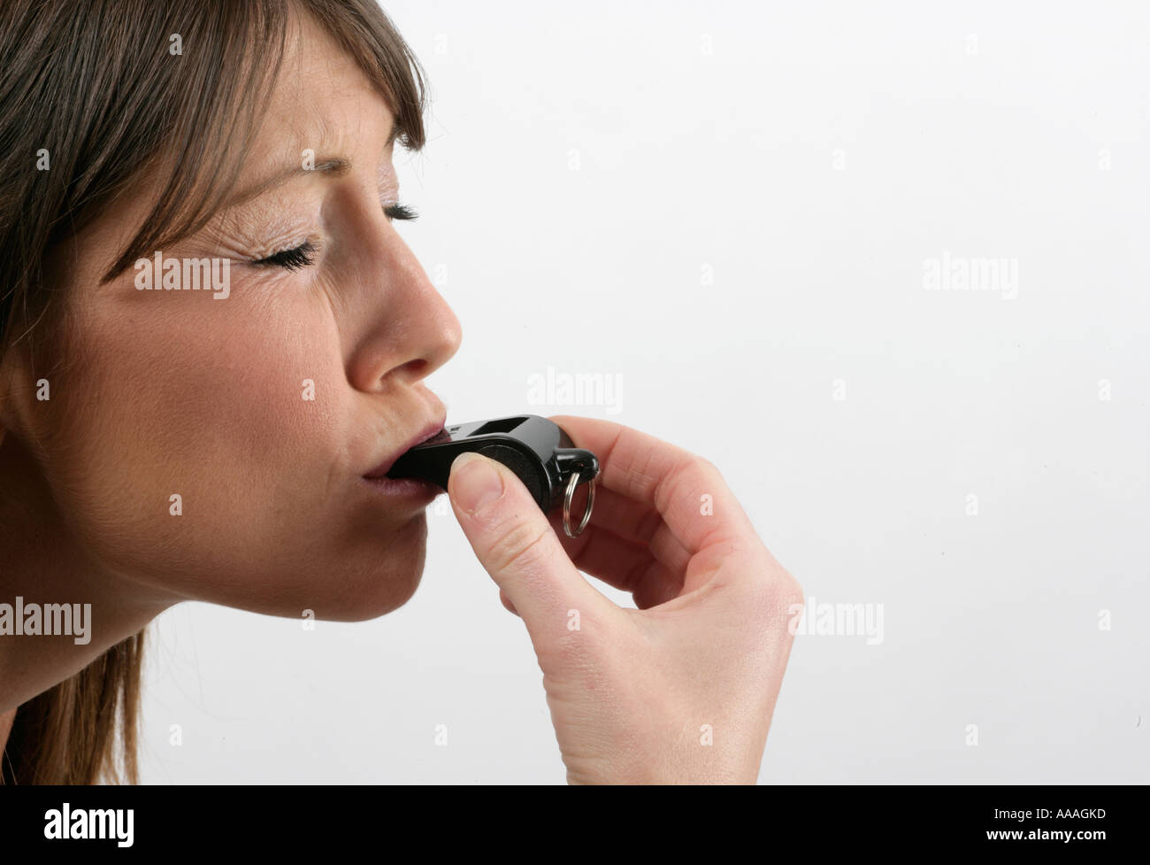 Young woman blowing a whistle hard The whistleblower Stock Photo - Alamy