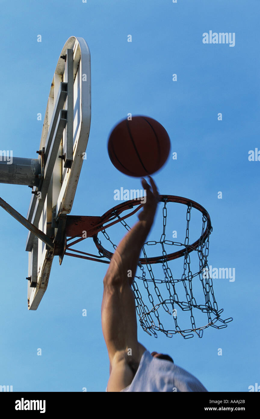 Low angle view of a person s hand shooting a basketball into the hoop ...