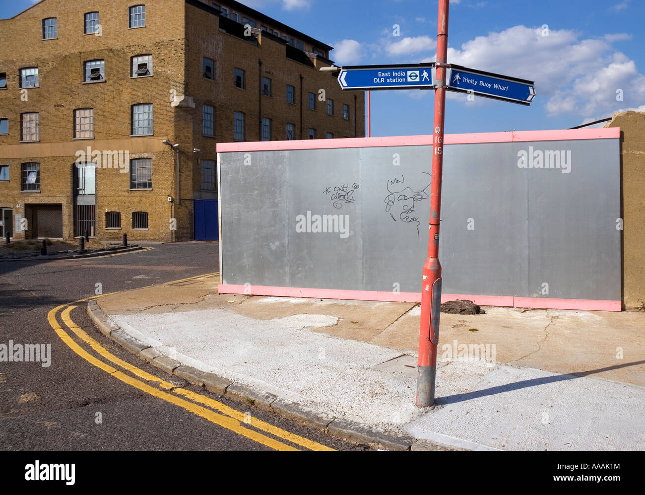 A quiet street corner in London Docklands with a signpost pointing to ...