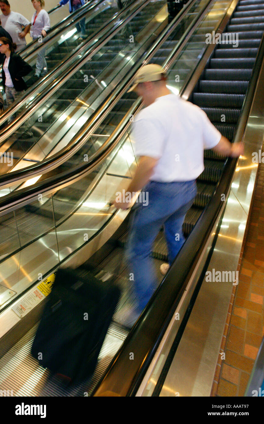Hustling up an airport escalator to catch a departing flight Stock ...