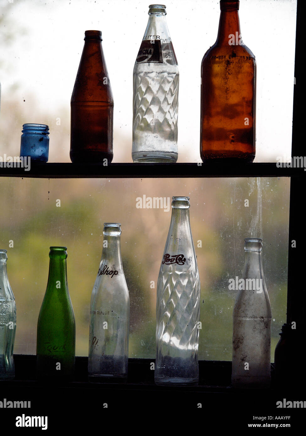 Collection of antique soda bottles on display in an old rural garage ...