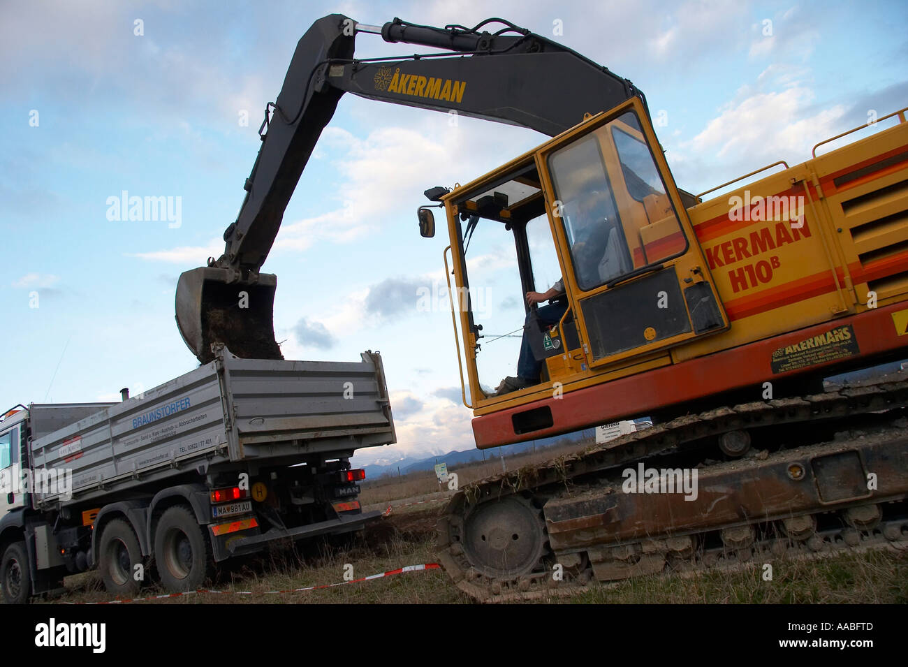 excavator loading earth onto lorry Stock Photo - Alamy