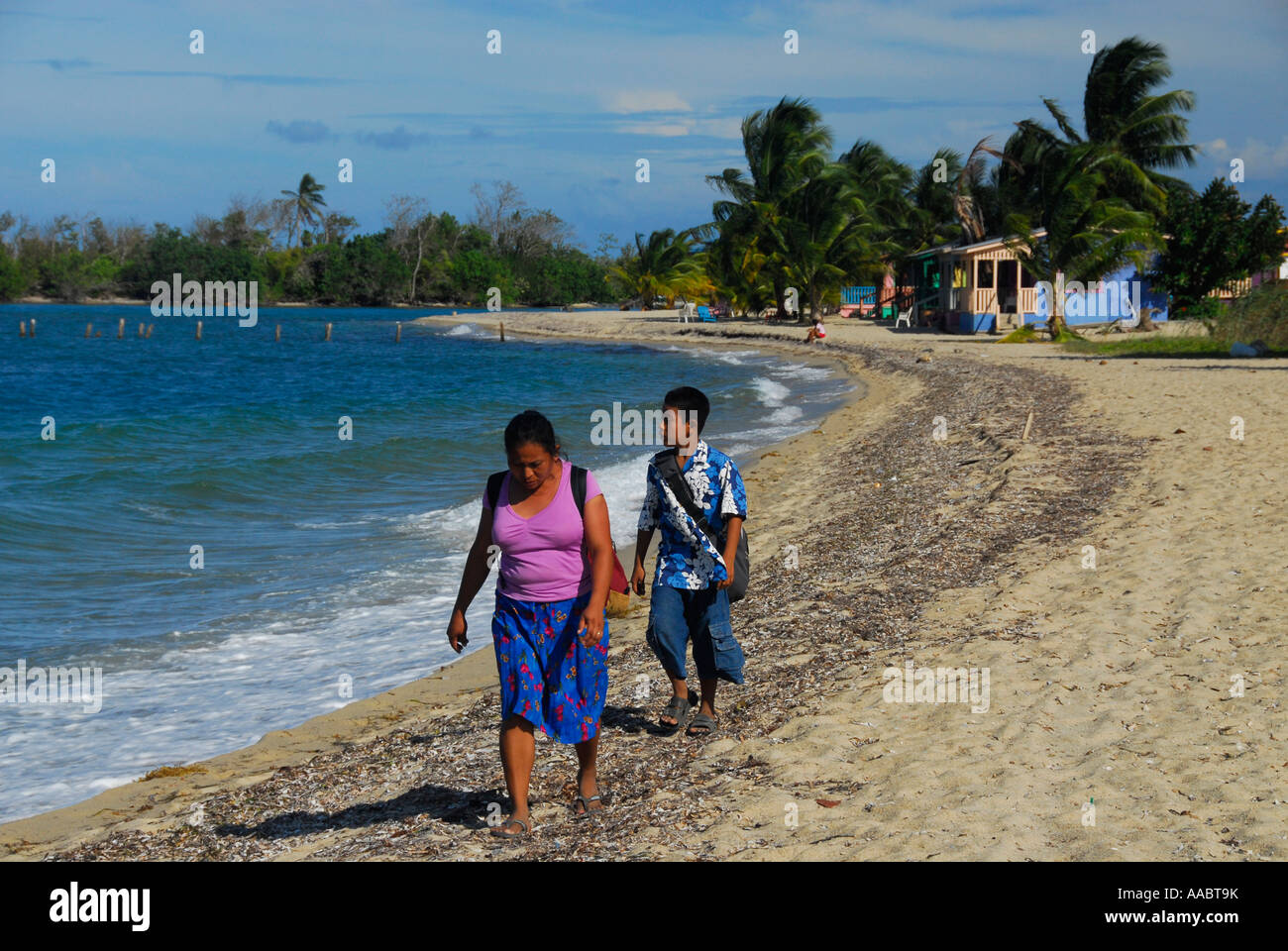 Indigenous family walking on beach of Placencia village, Caribbean Sea ...