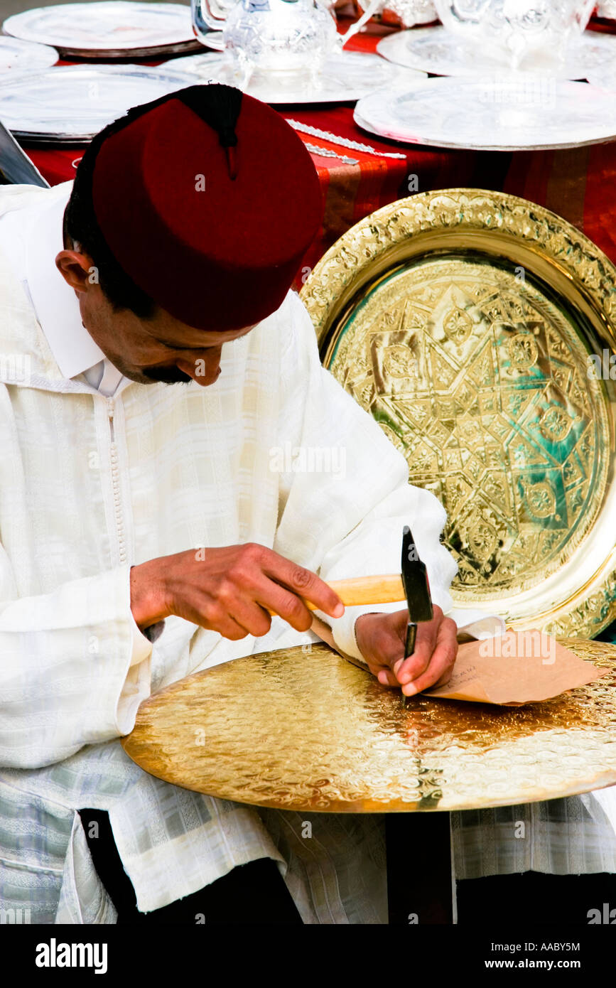 A Morrocan metal worker on the South Bank of the Thames hammers a ...