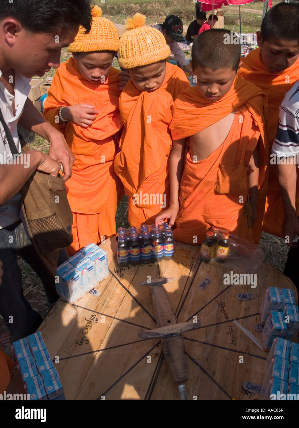 monks playing a version of spin the bottle at country fair in Laos ...