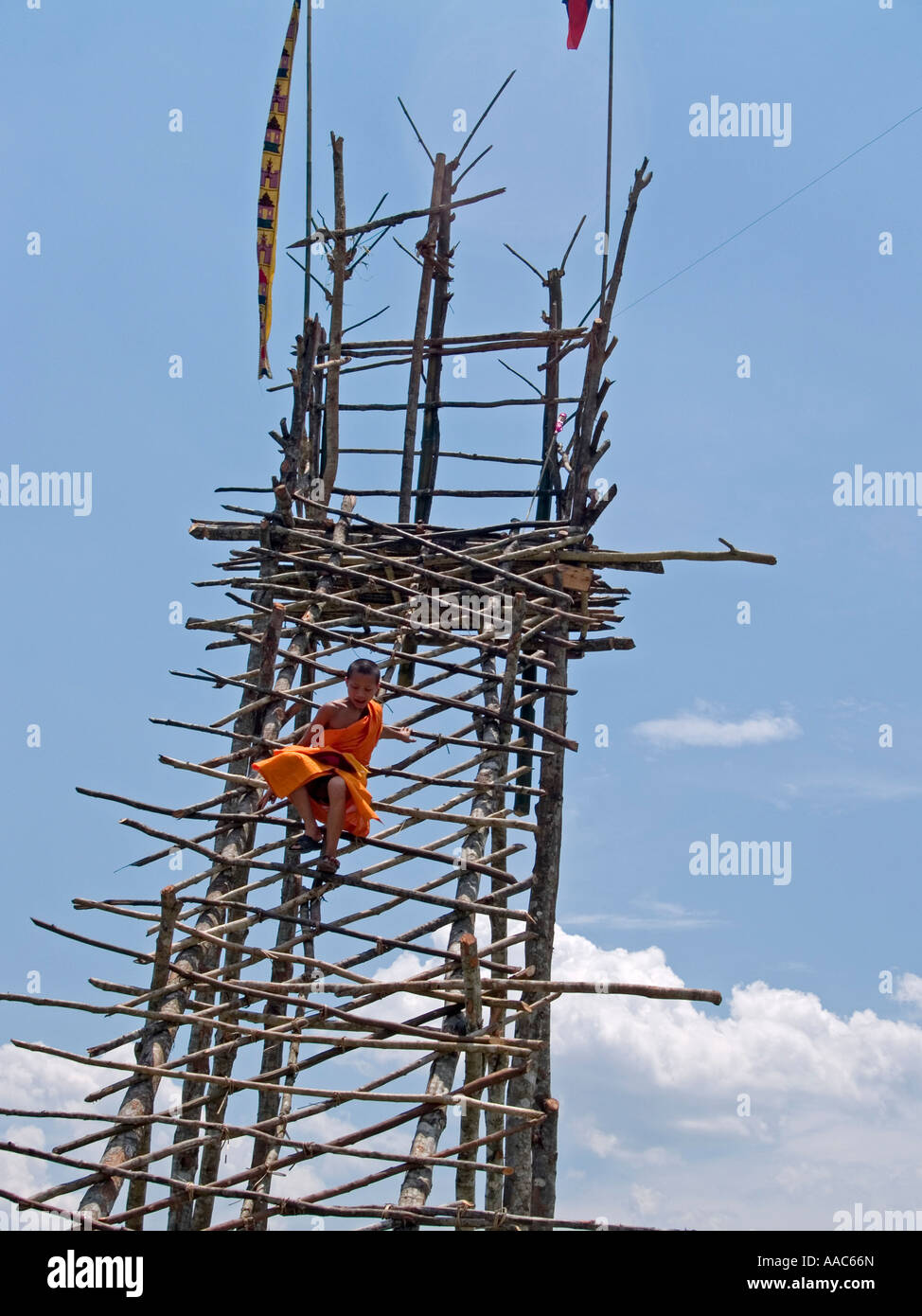 a boy monk descends a rocket tower after lighting a small bamboo rocket ...