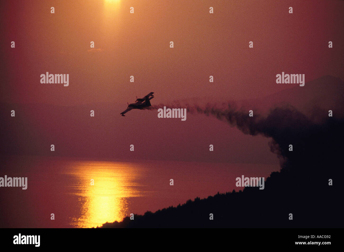 Aeroplane dropping water onto forest fire Stock Photo - Alamy
