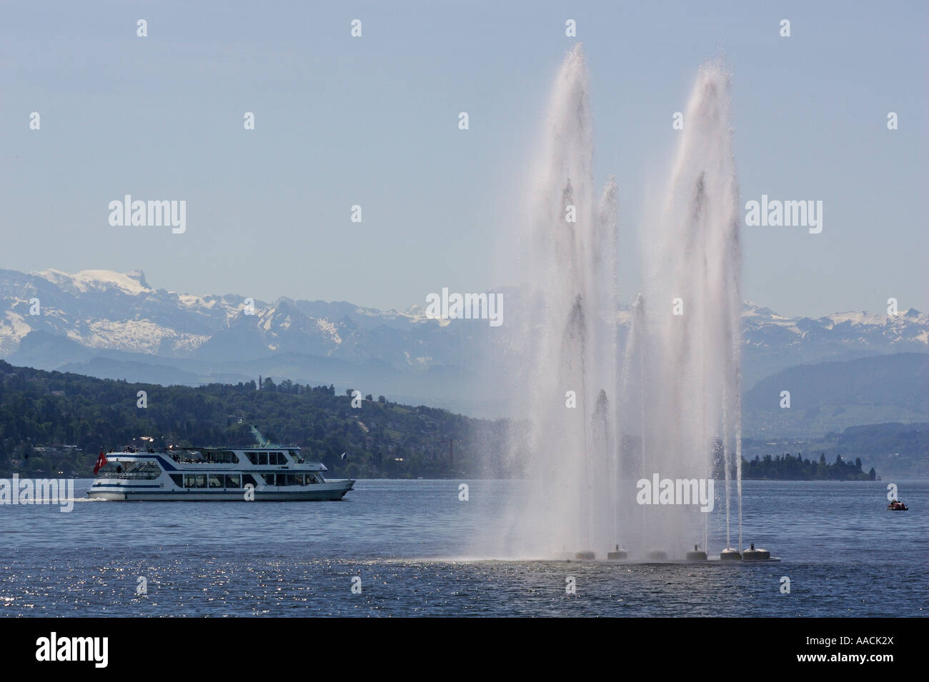 Water fountain in Zurich lake with excursion boat and Alp panorama ...