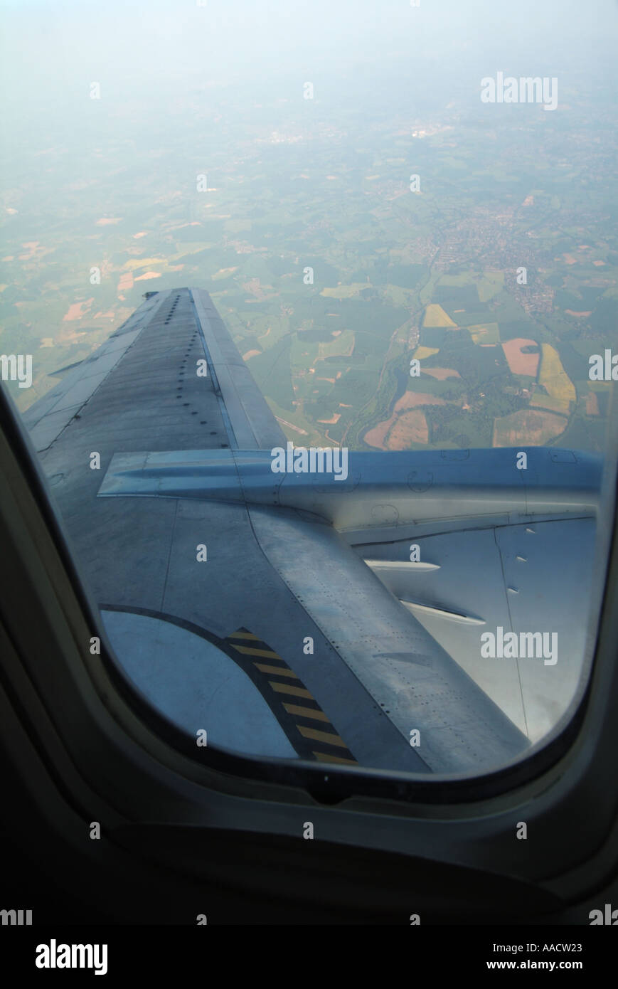 Aircraft window frame and view over rural part of southern England ...