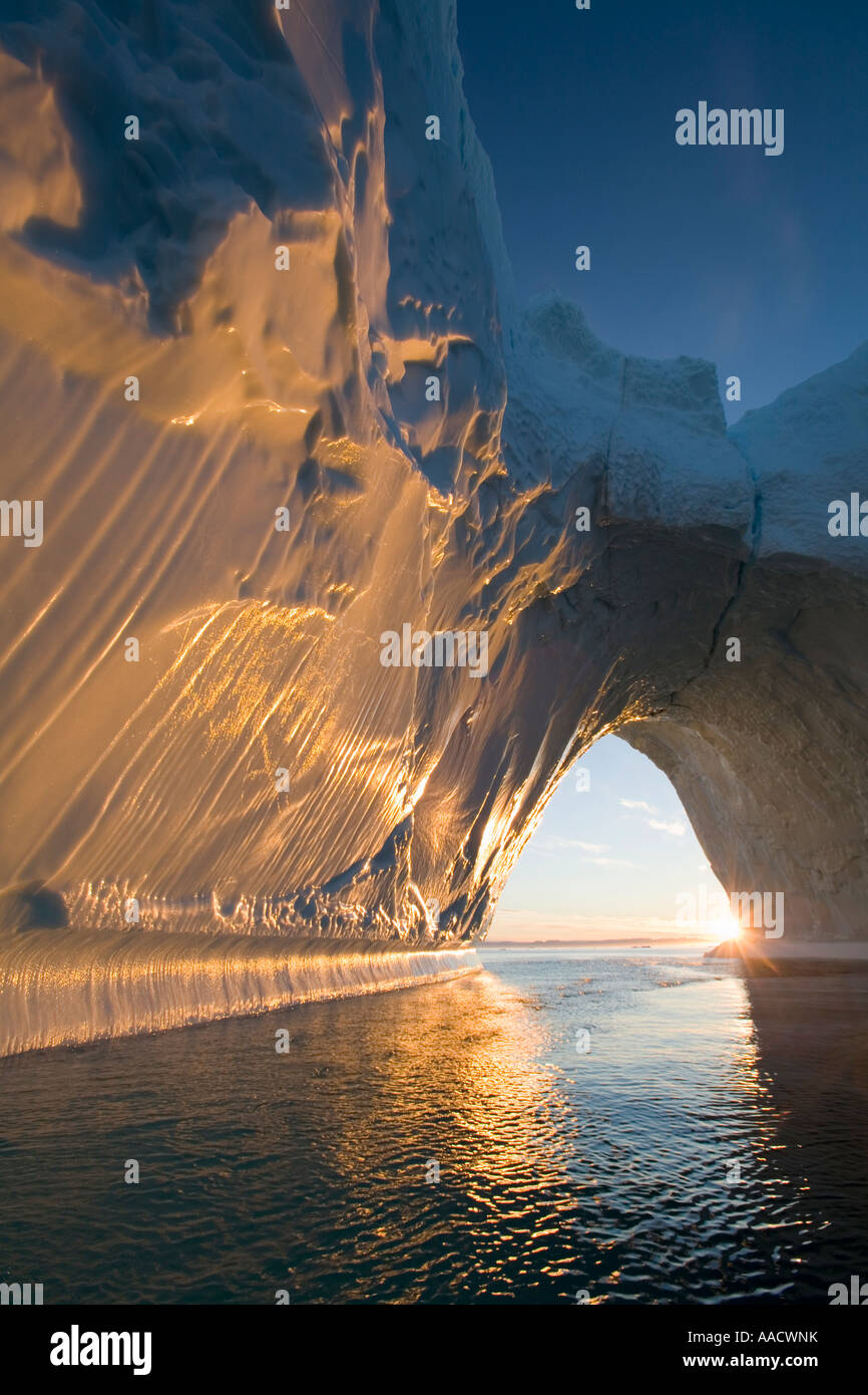 Greenland Ilulissat Setting midnight sun lights massive arched iceberg ...
