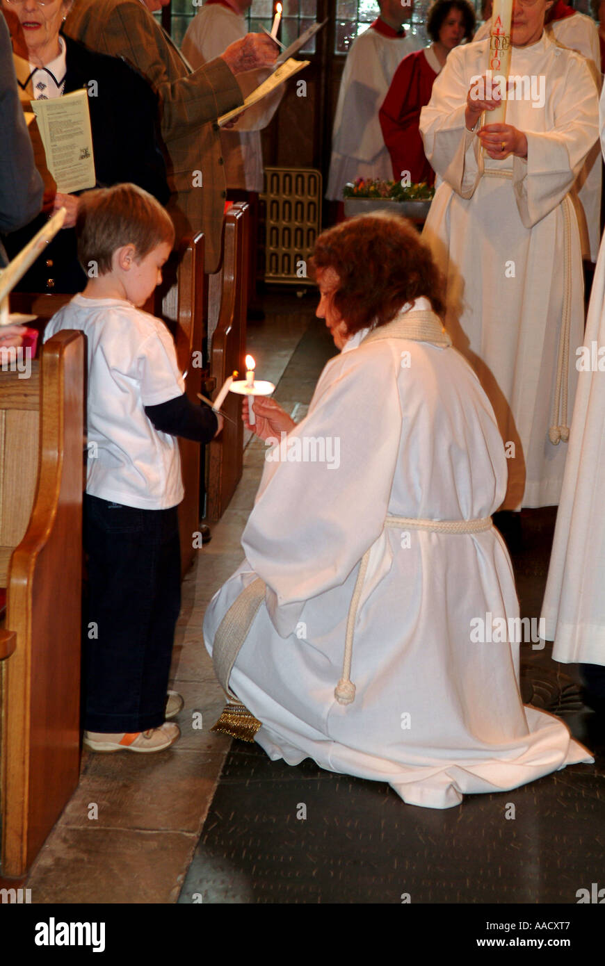 Revd Anne Le Bas lighting candles in the congregation Stock Photo - Alamy