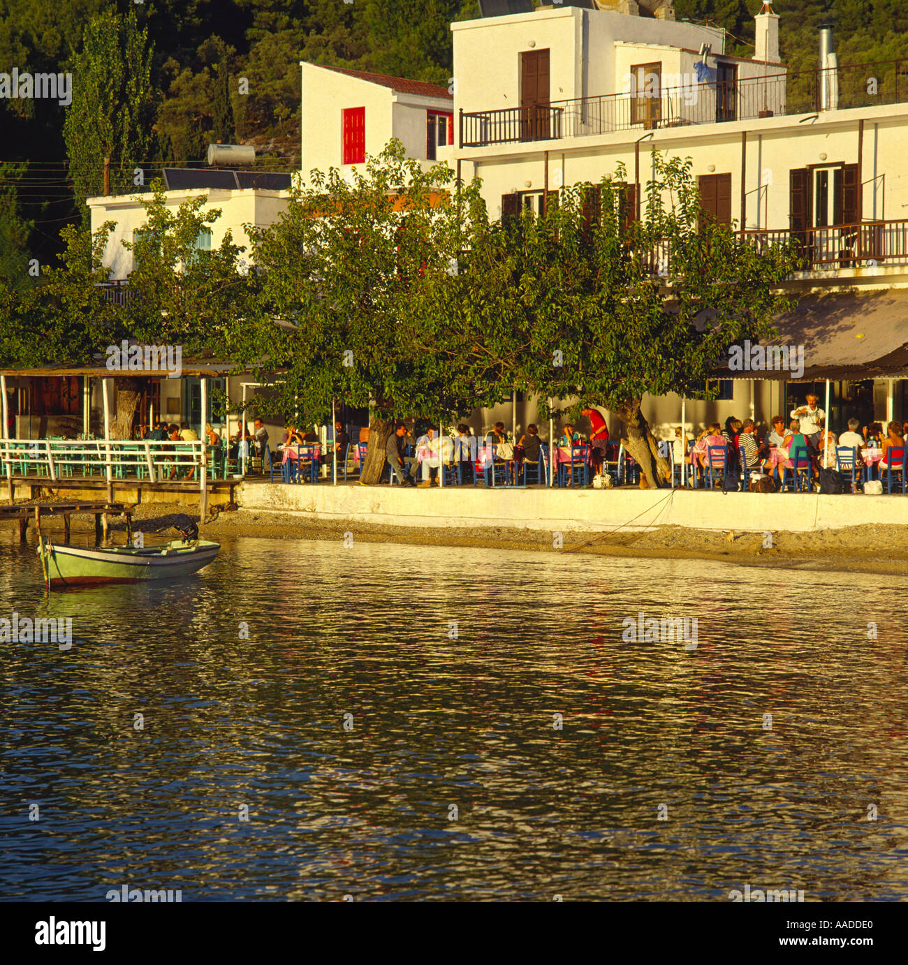 People enjoying late afternoon sunshine on veranda at waterside taverna ...