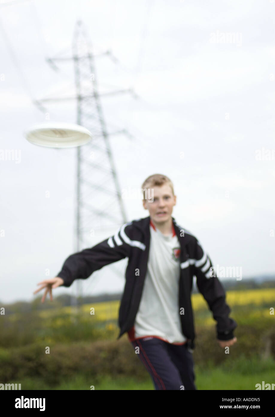 boy throwing frisbee with electricity pilon in background Stock Photo ...