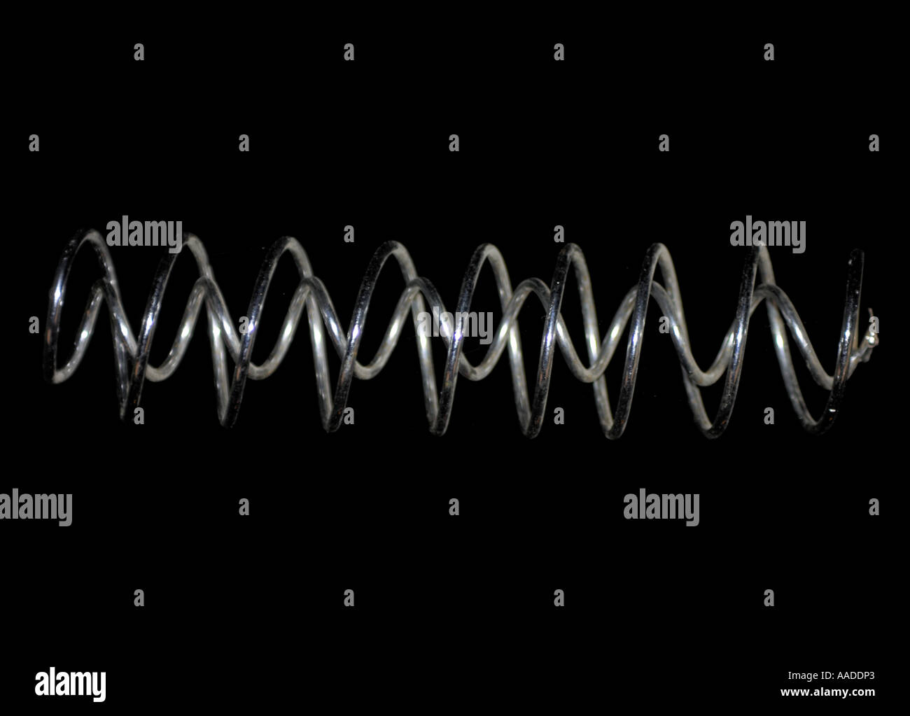 a coiled spring on a black background Stock Photo - Alamy