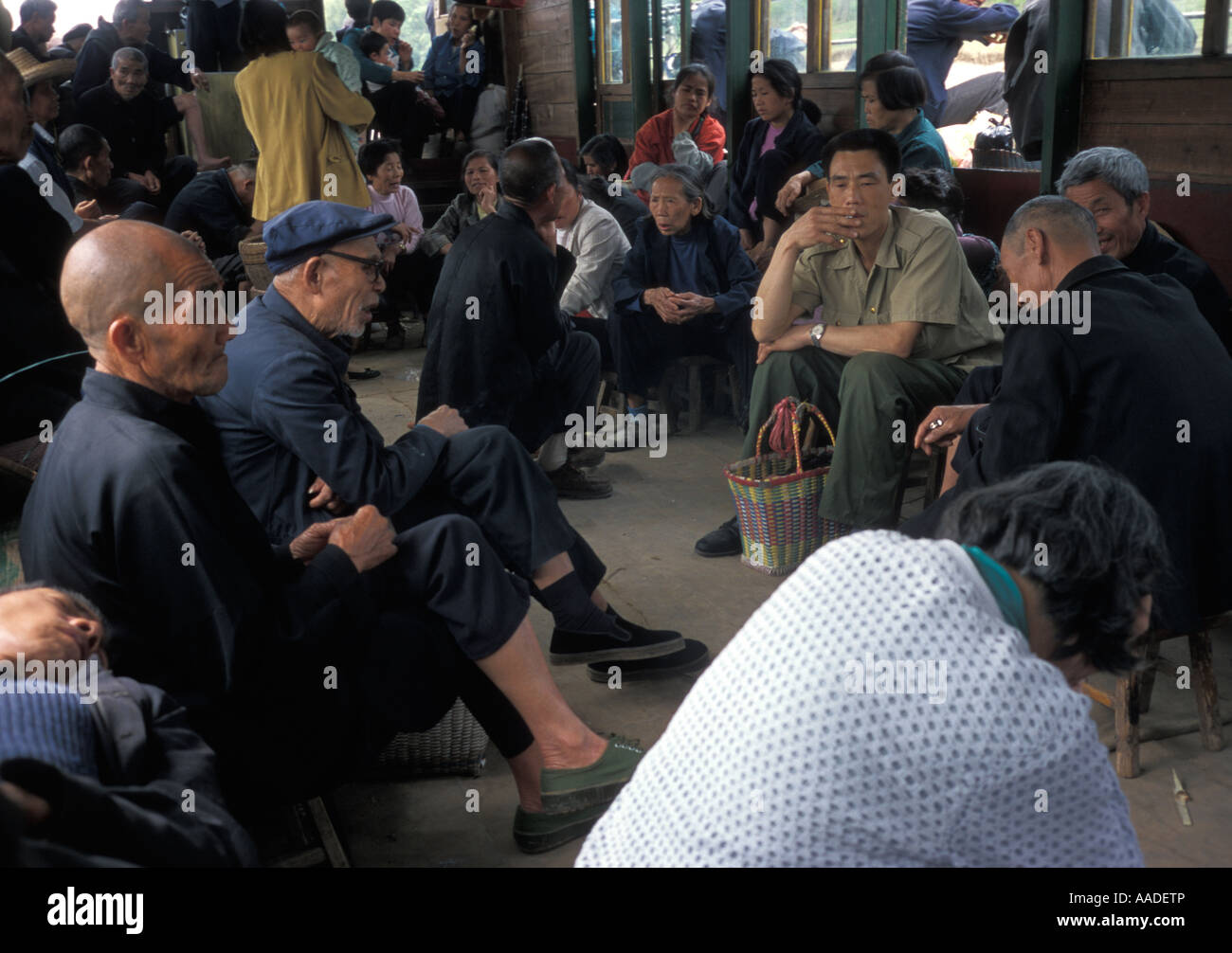 Chinese peasant farmers talking on a ferry back from market day in Fuli ...