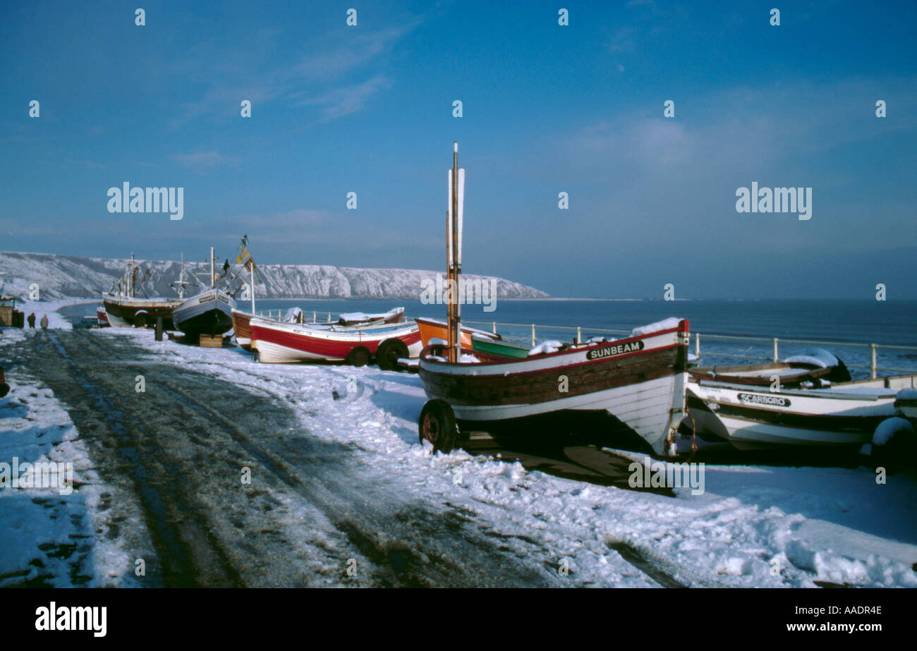 Coble fishing boats with cliffs beyond in winter, Filey, North ...