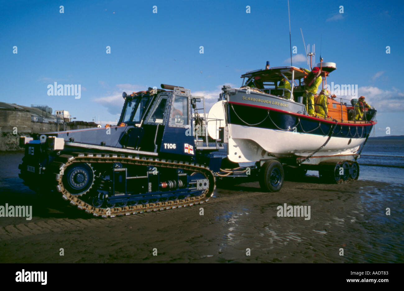 Lifeboat on a trailer being towed ashore by a caterpillar tracked ...