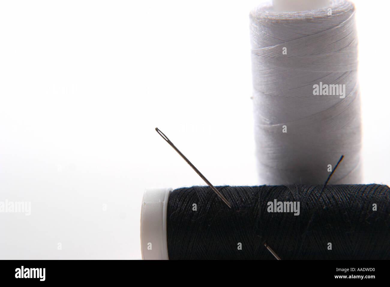 Black and white sewing threads with needle Stock Photo - Alamy