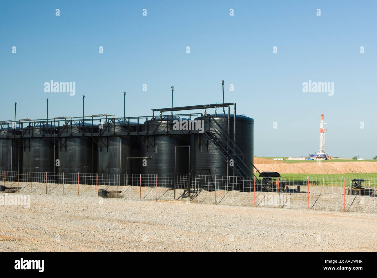 oil storage tanks and drilling derrick on a pad in the Texas Panhandle ...