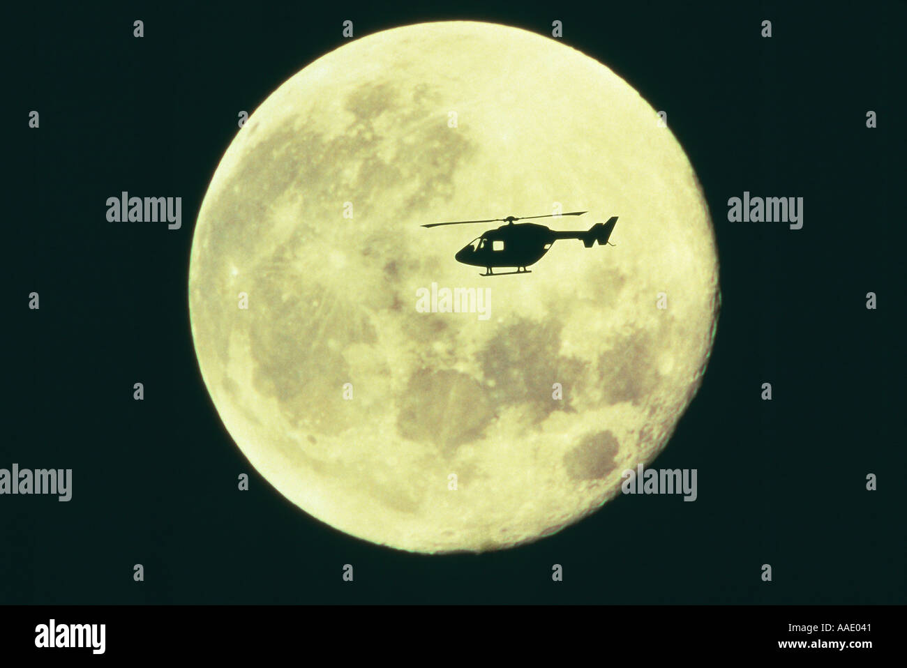 A helicopter is silhouetted against a full moon Stock Photo - Alamy