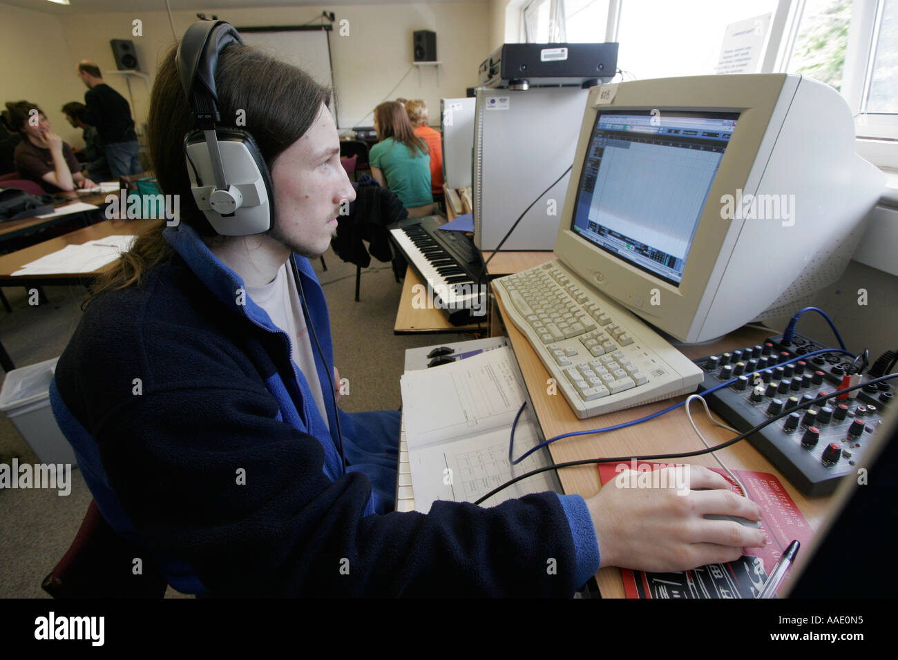 Male Student with headphones using Apple Macintosh computer in sixth ...