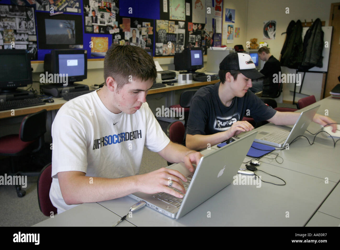 Two male teenage students using Apple Macintosh computers in sixth form ...