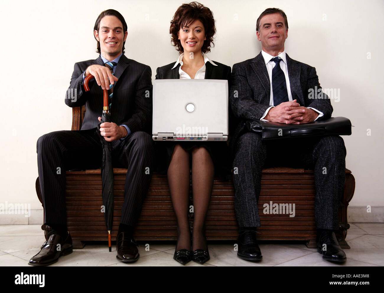 Three people sitting in a waiting room Stock Photo - Alamy