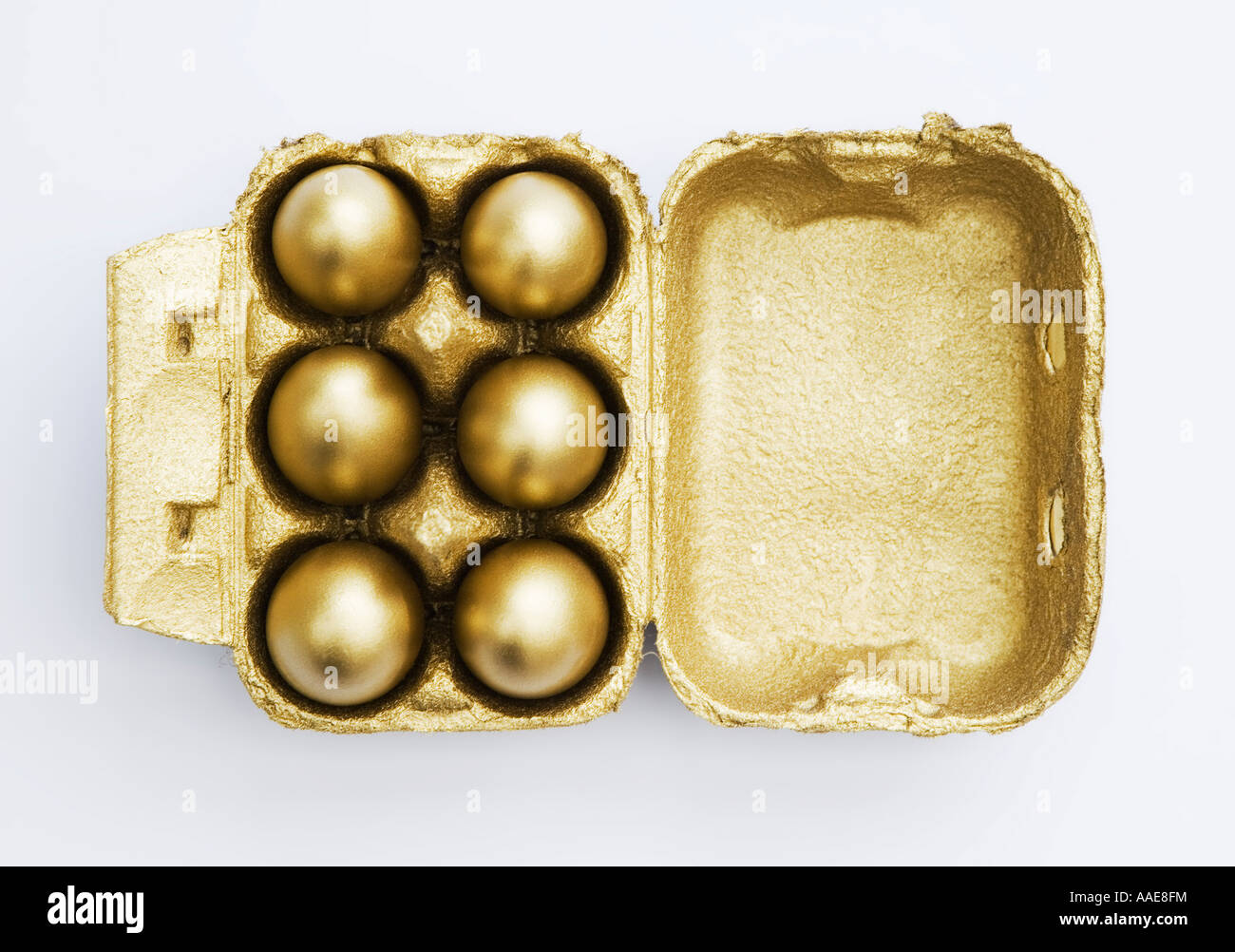 Golden eggs in an egg box on white background Stock Photo - Alamy