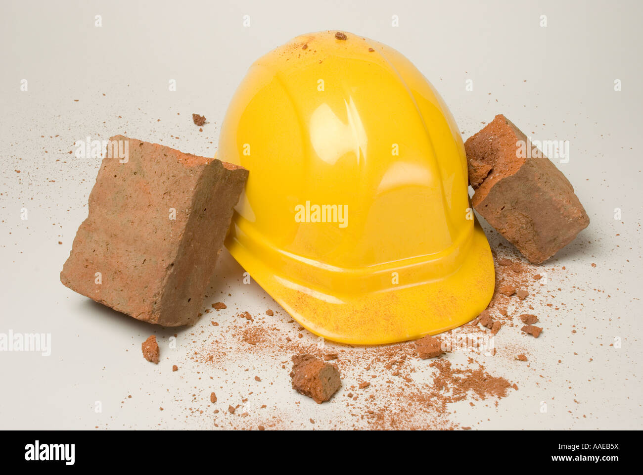 depiction of a hardhat breaking the fall of a brick Stock Photo - Alamy