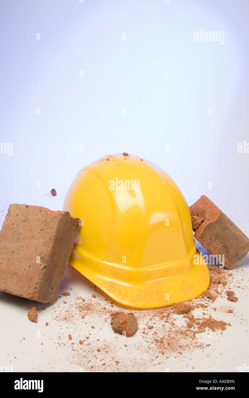 depiction of a hardhat breaking the fall of a brick Stock Photo - Alamy