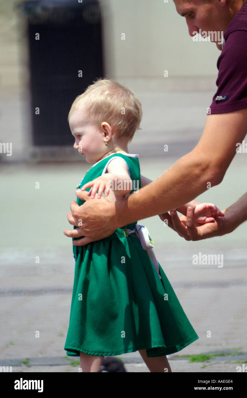 Father helping his daugter with first steps Stock Photo - Alamy