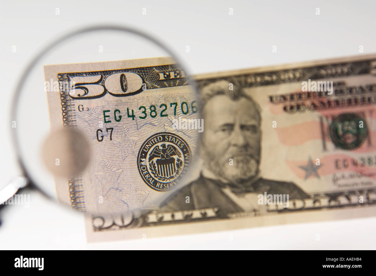 Money under a magnifying glass Stock Photo - Alamy