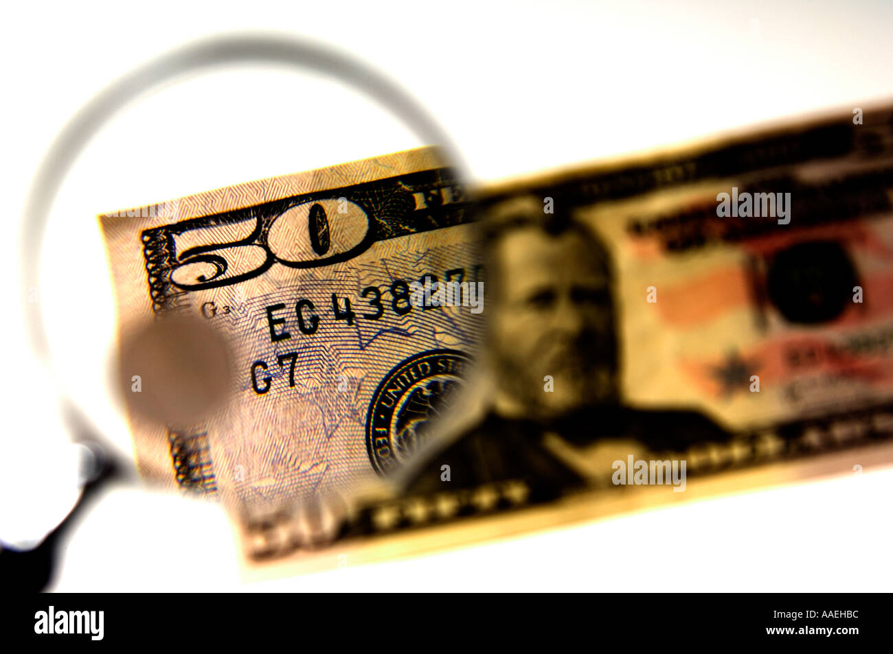 Money under a magnifying glass Stock Photo - Alamy
