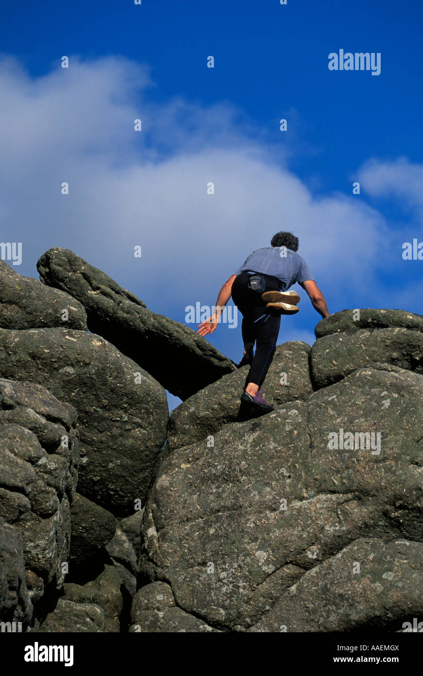 Man climbing on the Hound Tor Dartmoor National Park Devon England ...