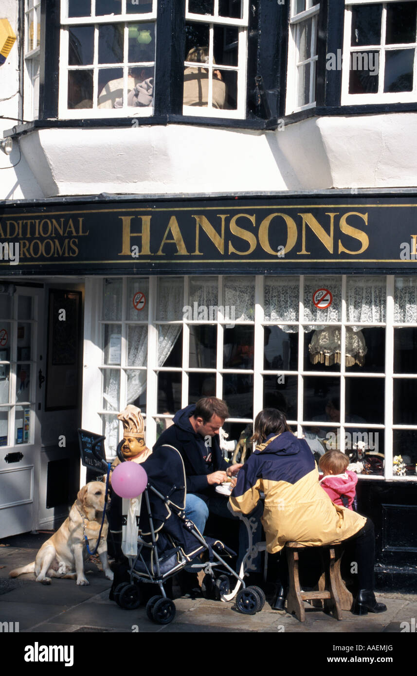 Family sitting in a pavement cafe Cathedral Close Exeter Devon England ...