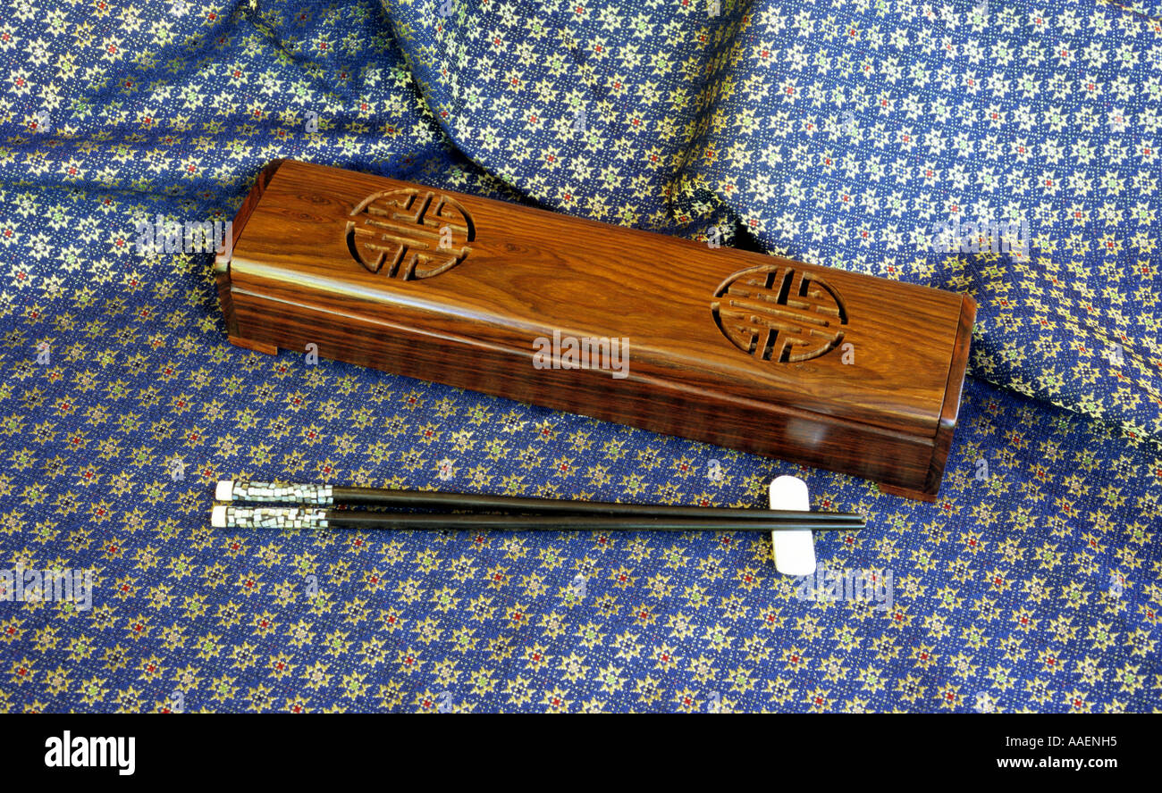 Vietnamese wood and shell chopsticks and a carved wooden box arranged ...
