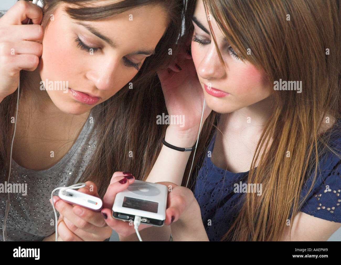 Two girls listening music ipod hi-res stock photography and images - Alamy