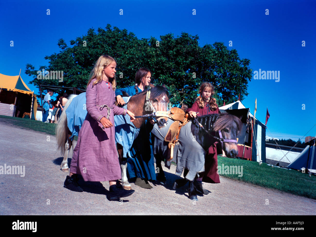 Girls with ponies at medieval fair camp Stock Photo - Alamy