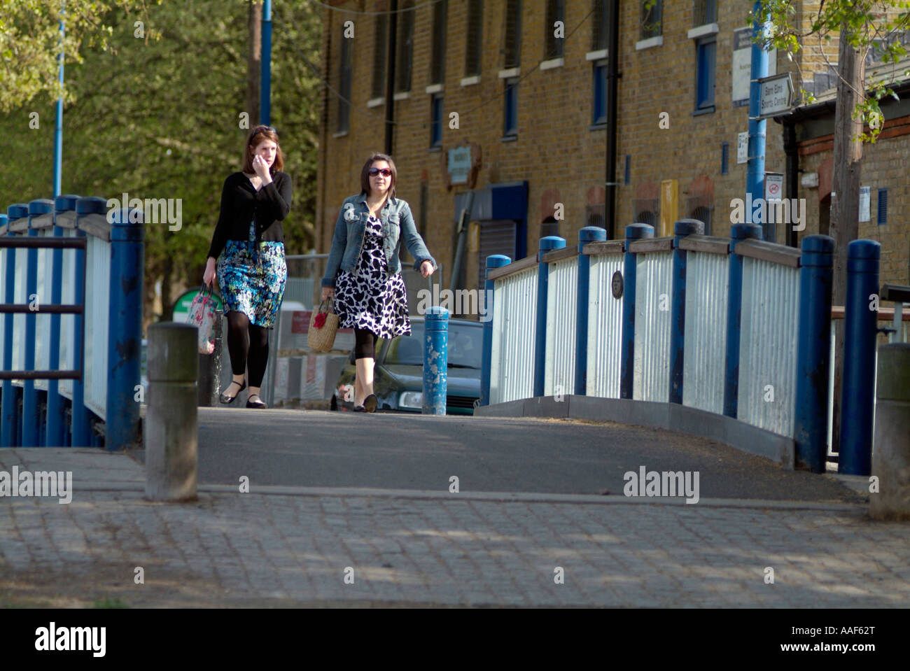 two women walking over bridge putney london england Stock Photo - Alamy