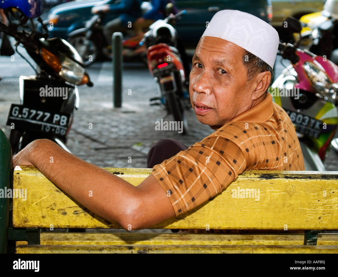 Local man wearing muslim hat relaxing on a bench in Yogyakarta,Java ...