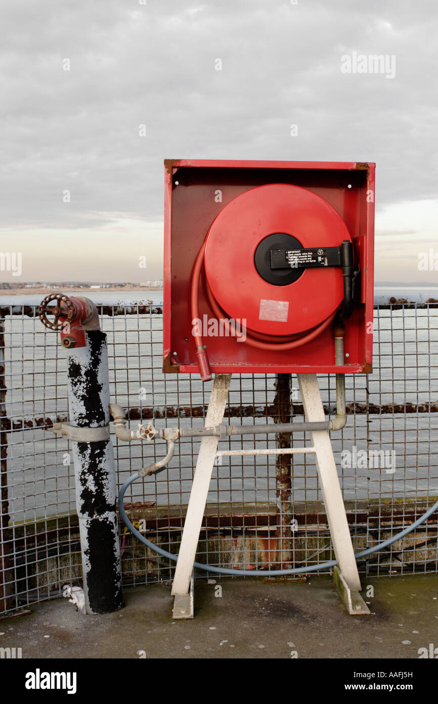 Fire hydrant reel and hose on seaside pier Stock Photo - Alamy