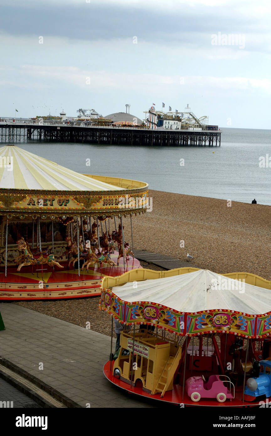 Palace pier Brighton with funfair merry go round on pebble beach Stock ...