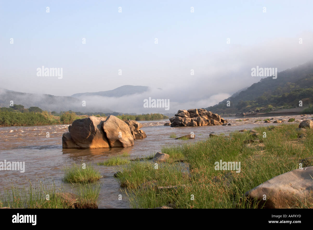 Rocks and reeds in the Blue Nile river with clouds in mountains near ...