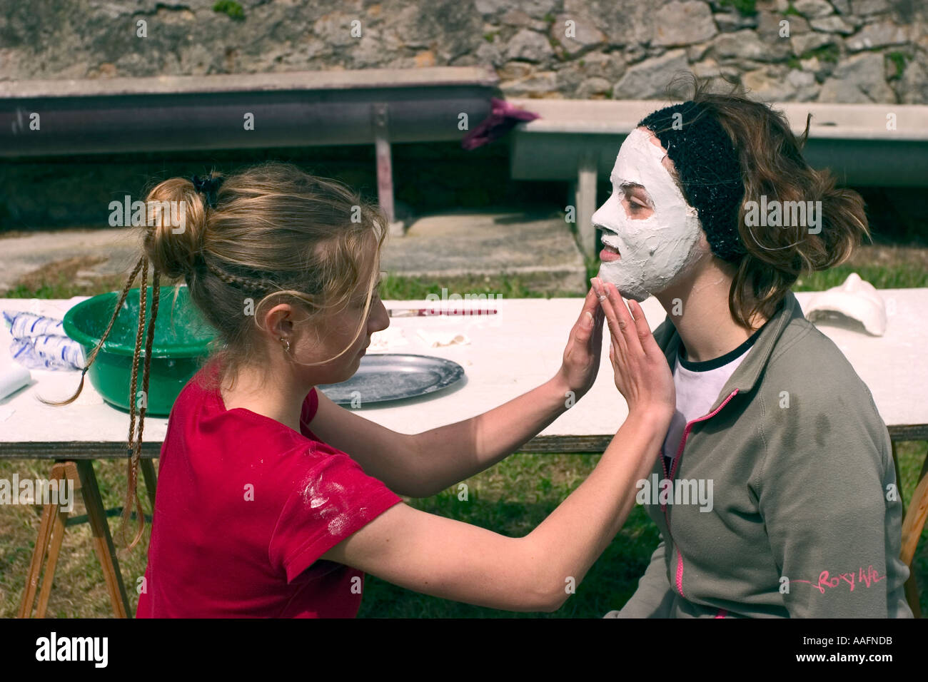 2 girls doing a plaster mask Stock Photo - Alamy