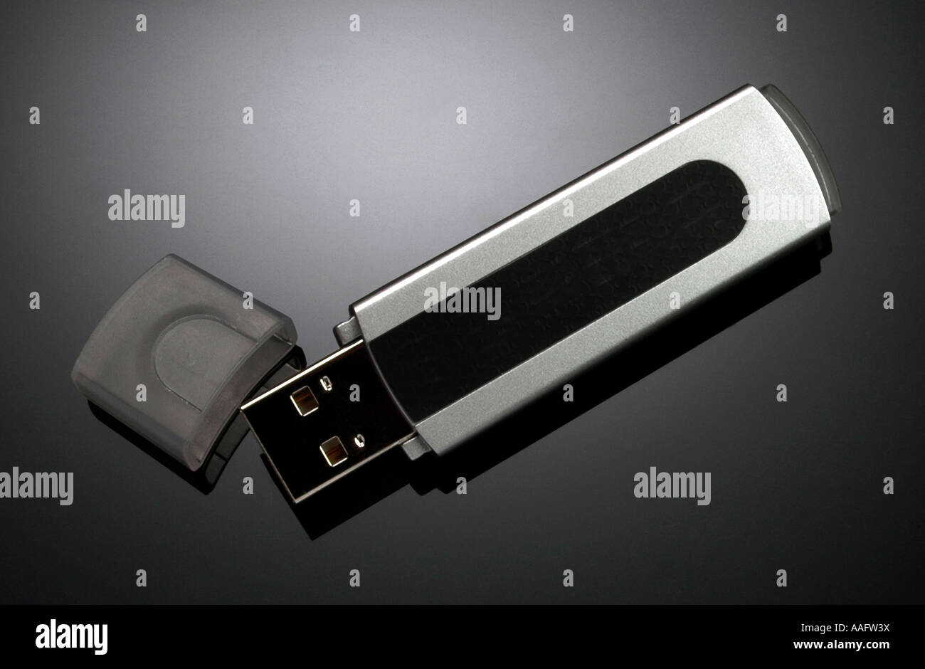 USB Flash Memory Stick drive. Photographed in light pool on reflective ...