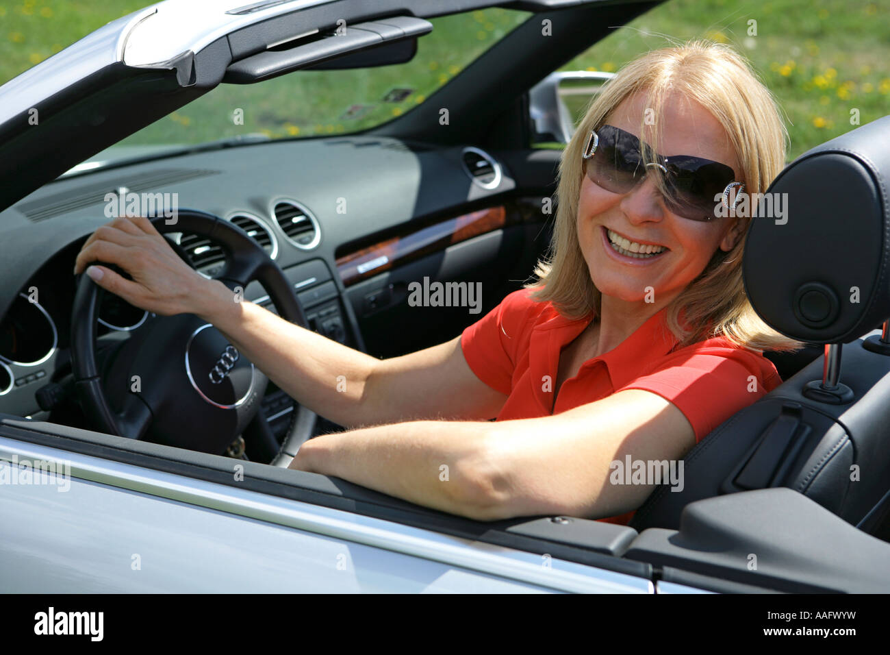 A senior woman driving cabriolet sportscar with roof down Stock Photo ...