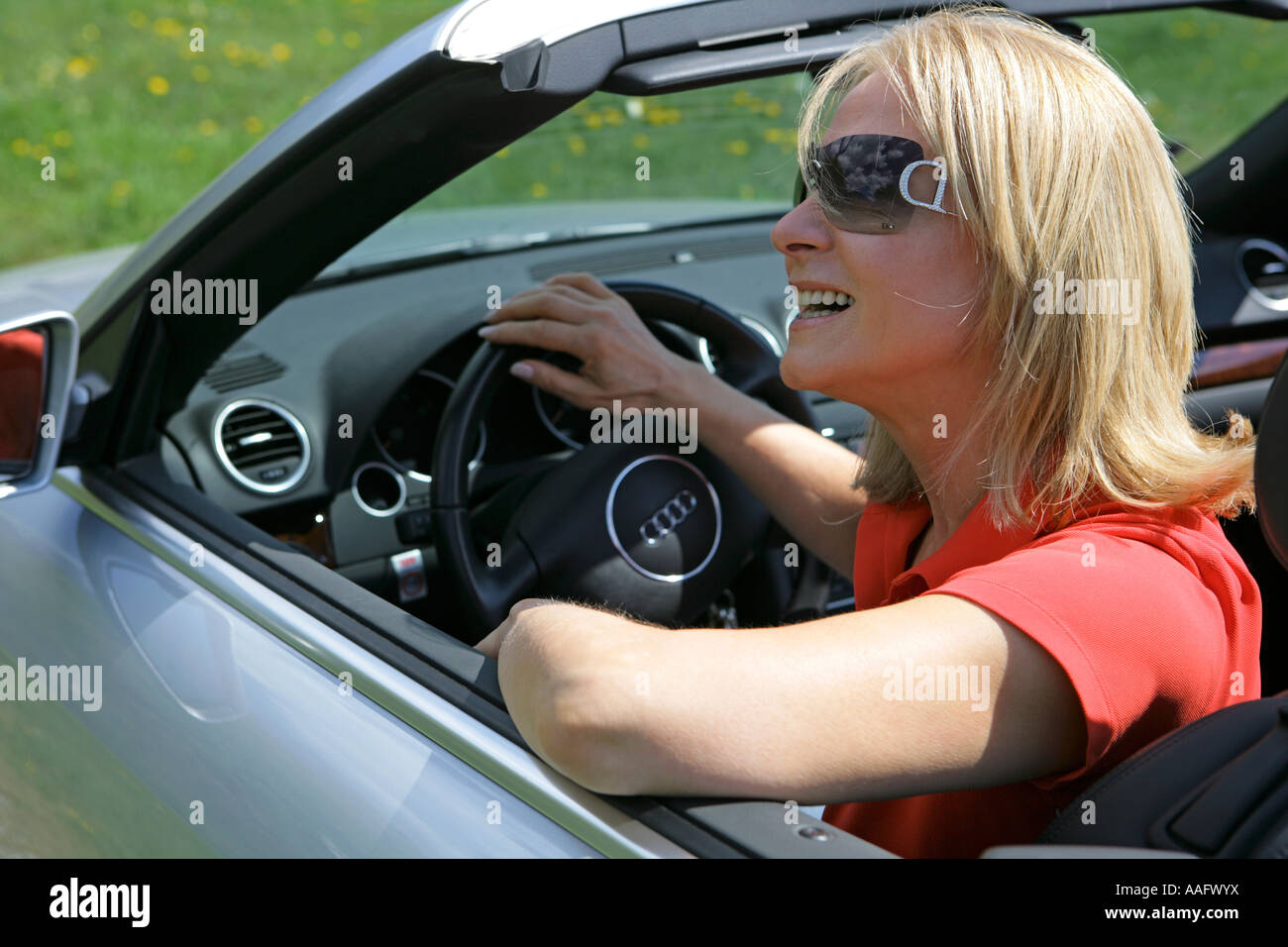 A senior woman driving cabriolet sportscar with roof down Stock Photo ...